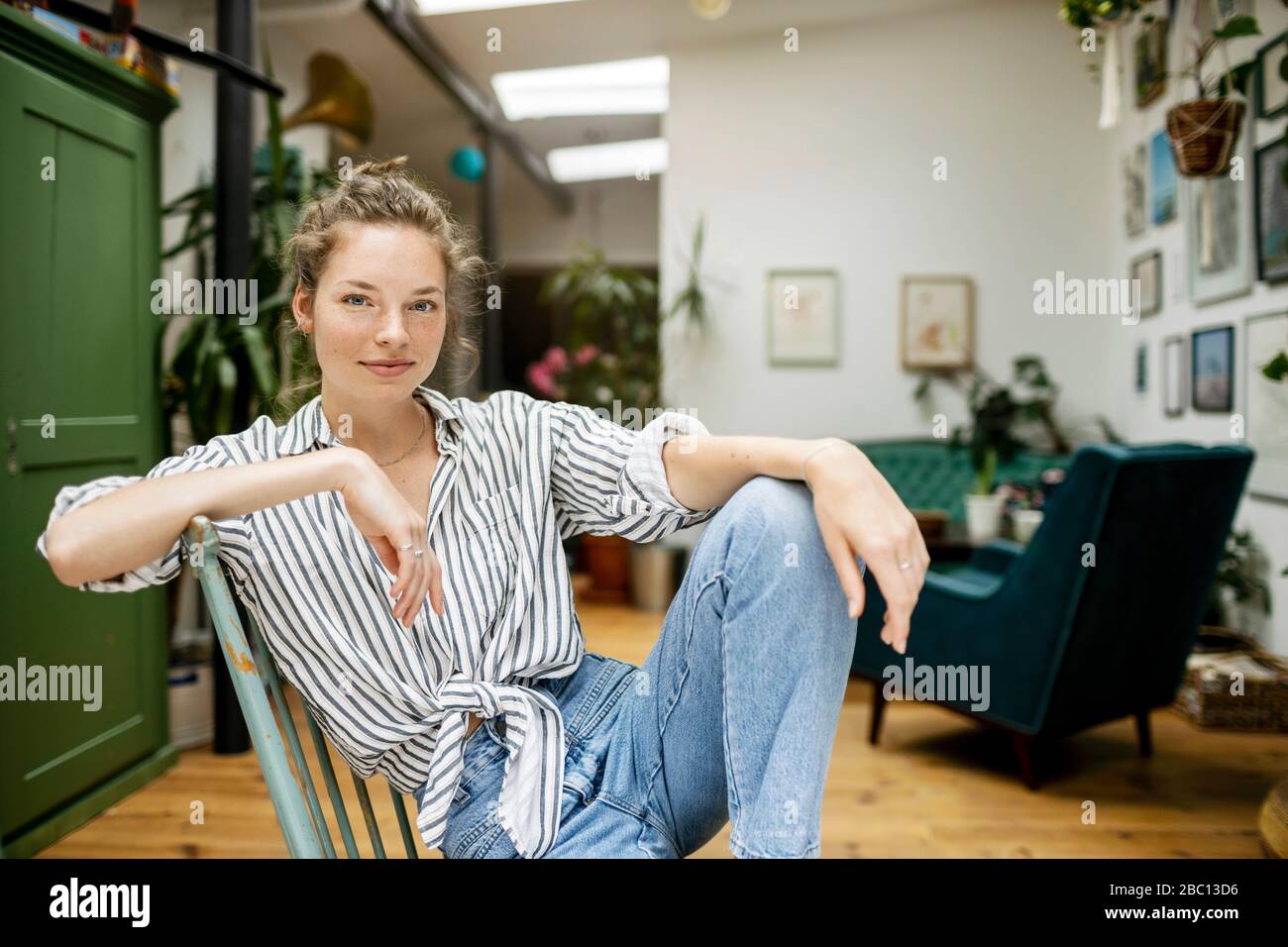 Young woman sitting relaxed on chair Stock Photo - Alamy