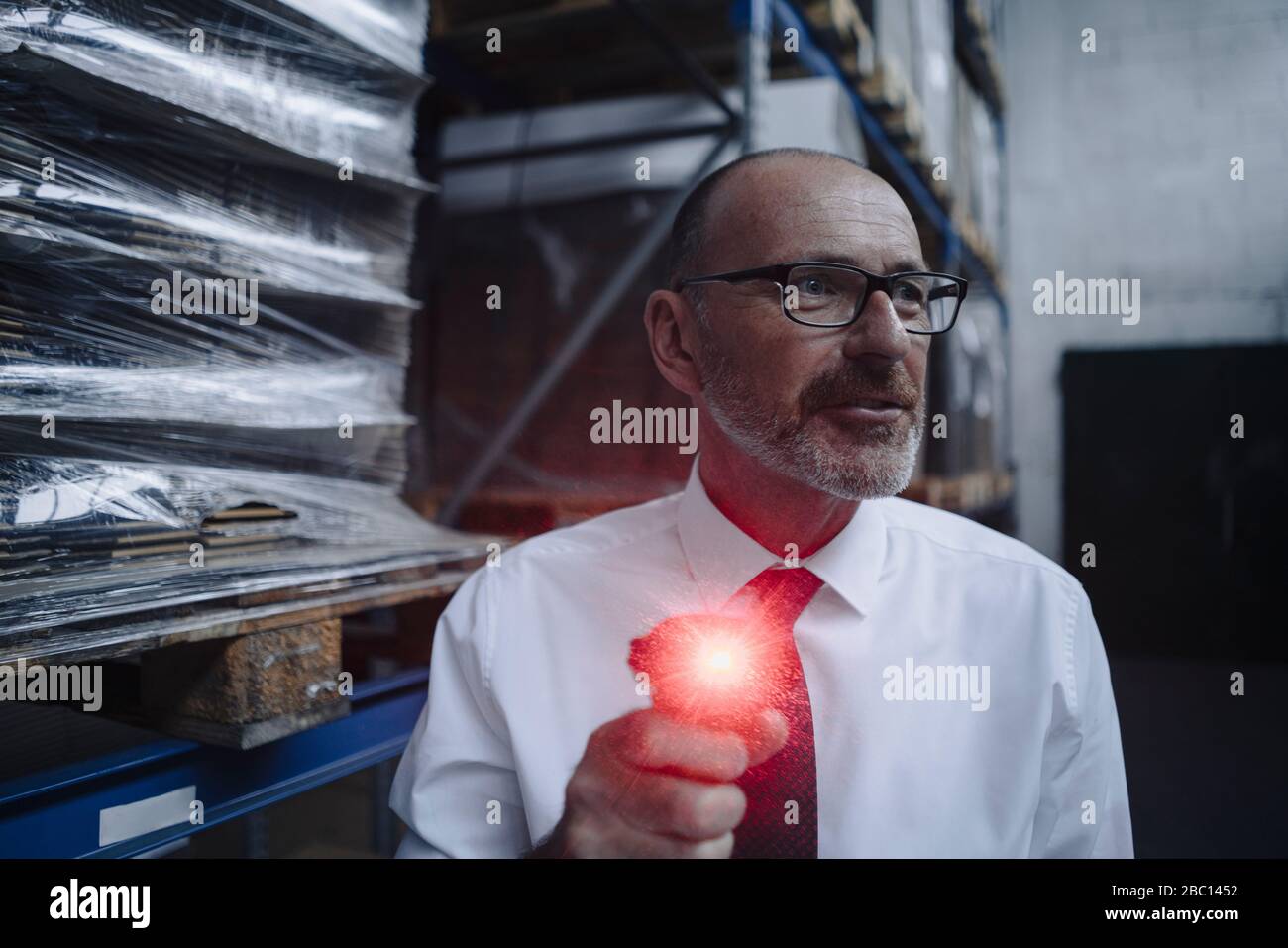 Man with glowing scanner in factory warehouse Stock Photo - Alamy