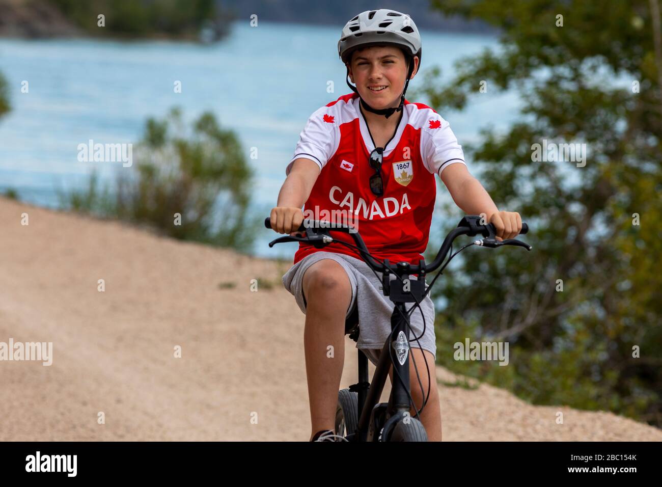 Twelve year old boy riding the Rail Trail around Kalamalka Lake in the ...