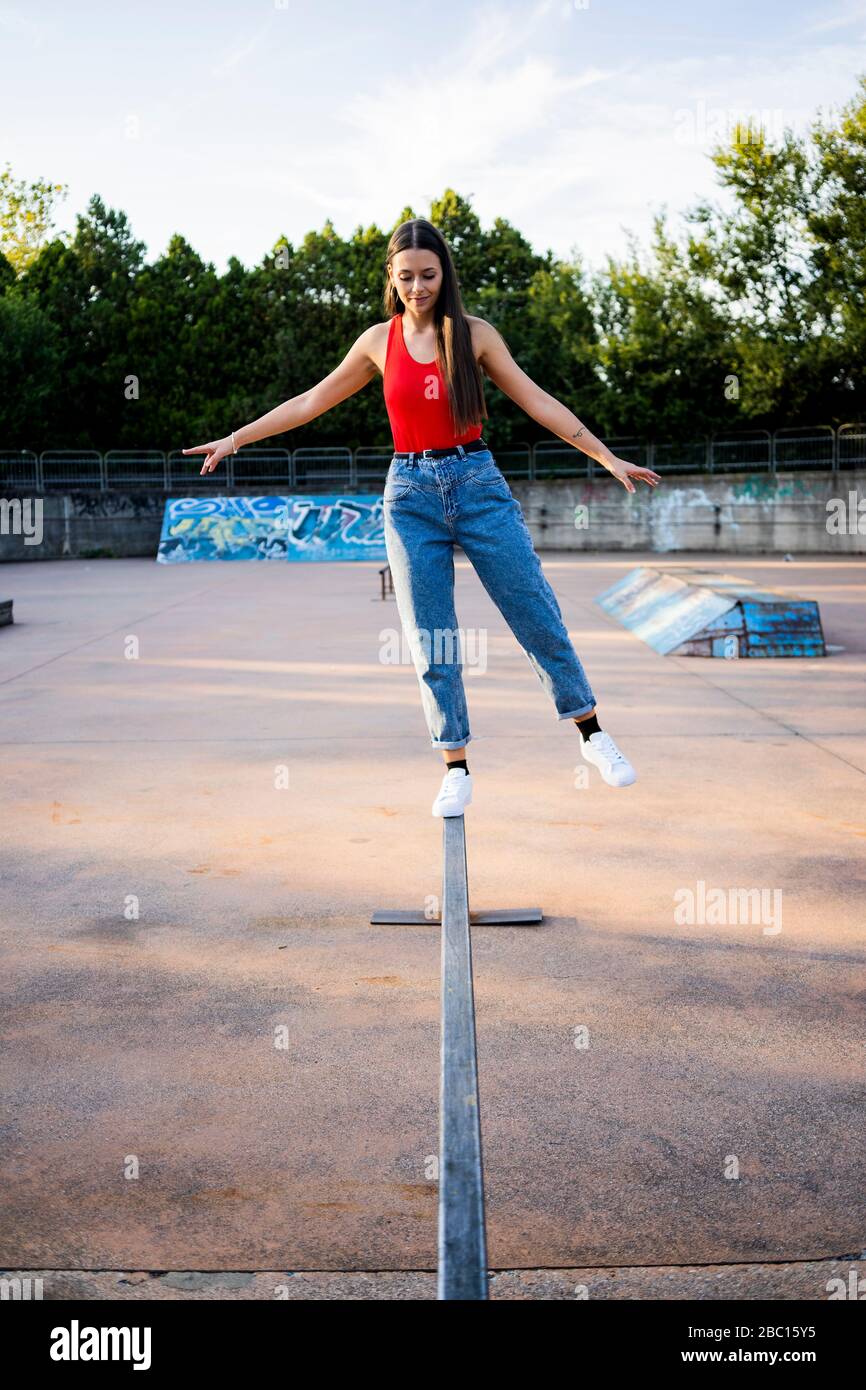 Young woman balancing on a rail at skatepark Stock Photo - Alamy