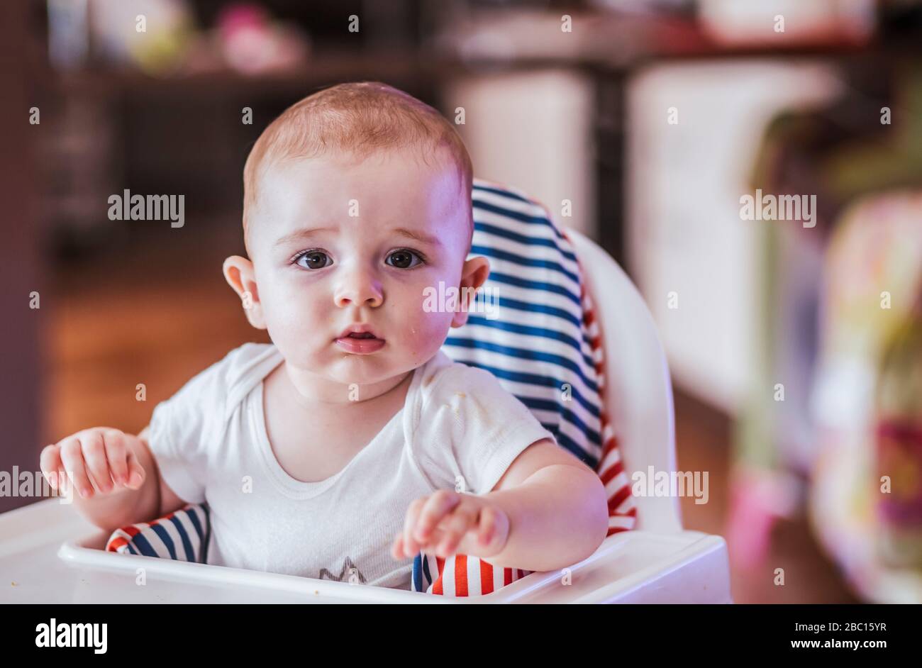 Portrait of baby boy sitting in high chair Stock Photo - Alamy