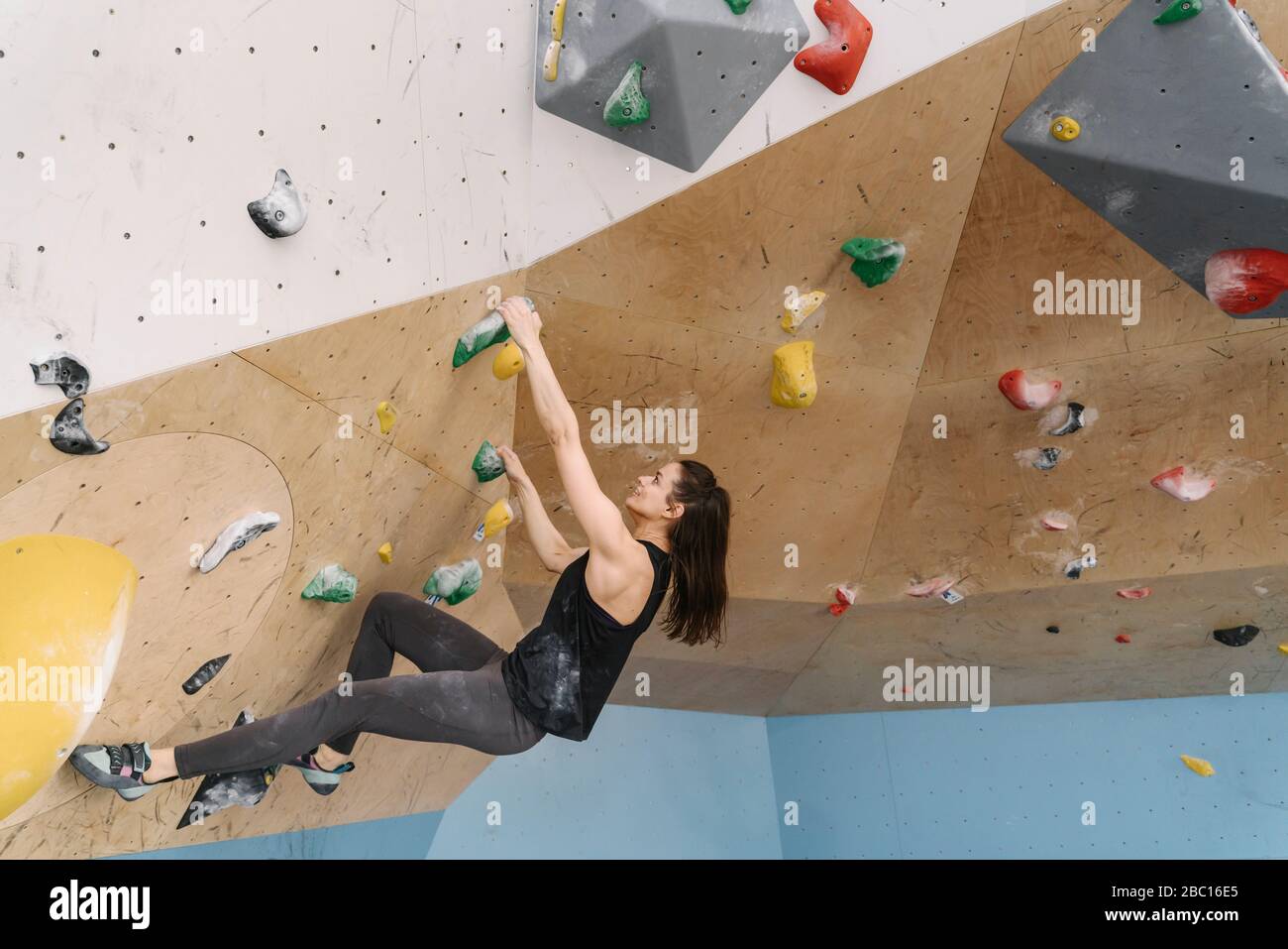 Woman bouldering in climbing gym Stock Photo - Alamy