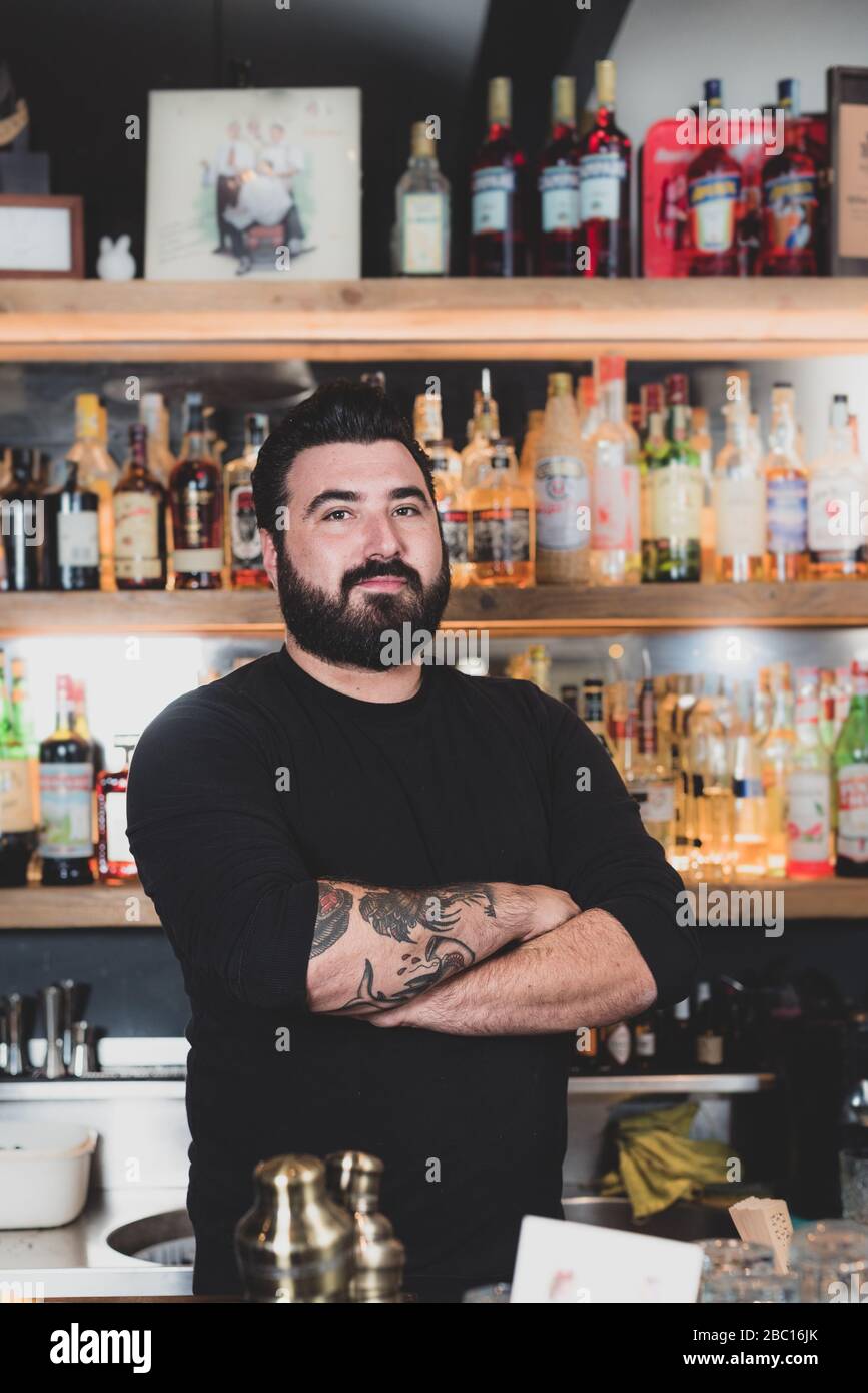 Young bartender smiles at you while you're at the counter with ...