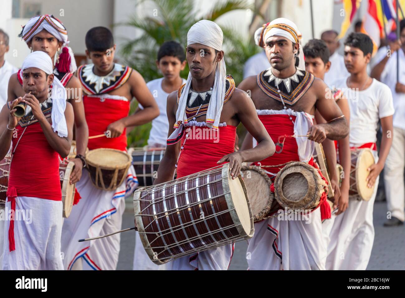 Men dressed in traditional attire playing drums and horns during a ...