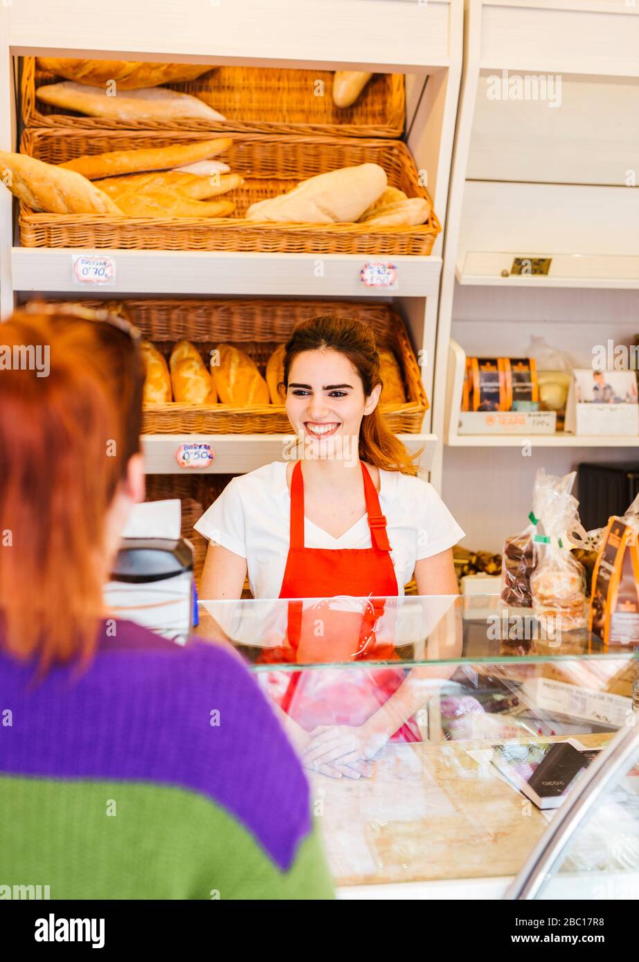 Young woman serving female customer in a bakery Stock Photo - Alamy