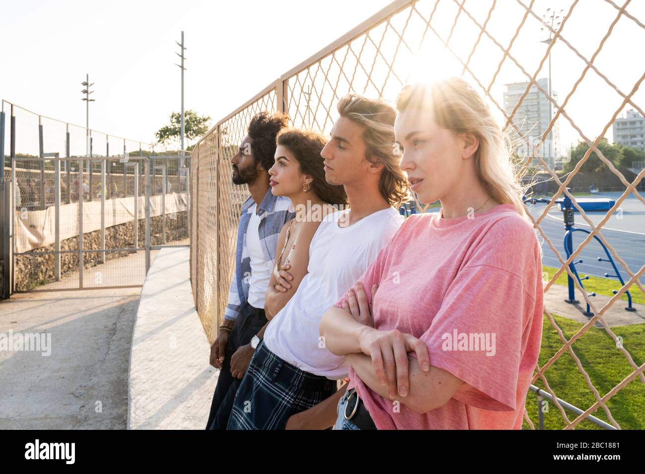 Portrait of cool friends at a wire mesh fence Stock Photo - Alamy