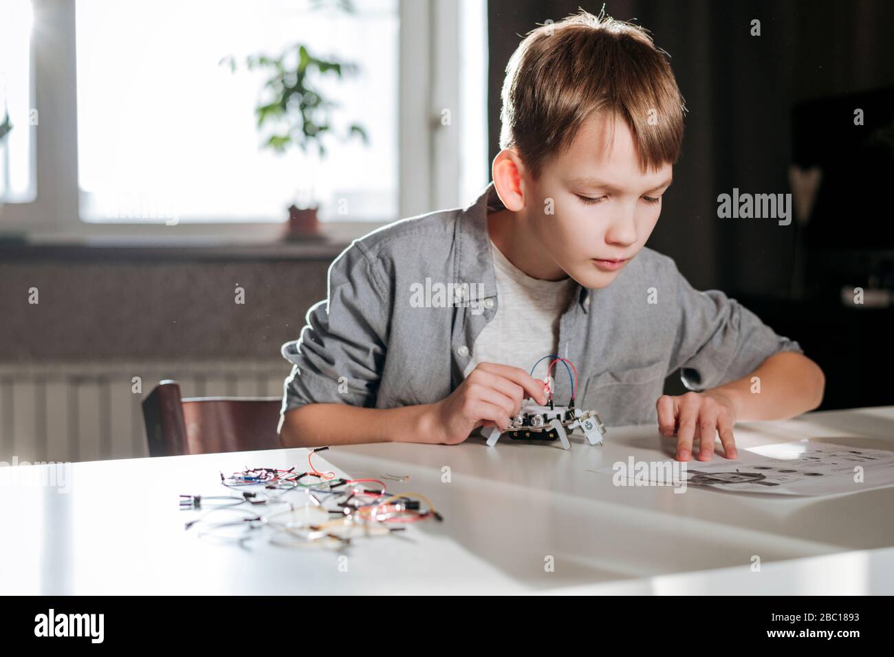 Boy making robot up with instruction at home Stock Photo - Alamy