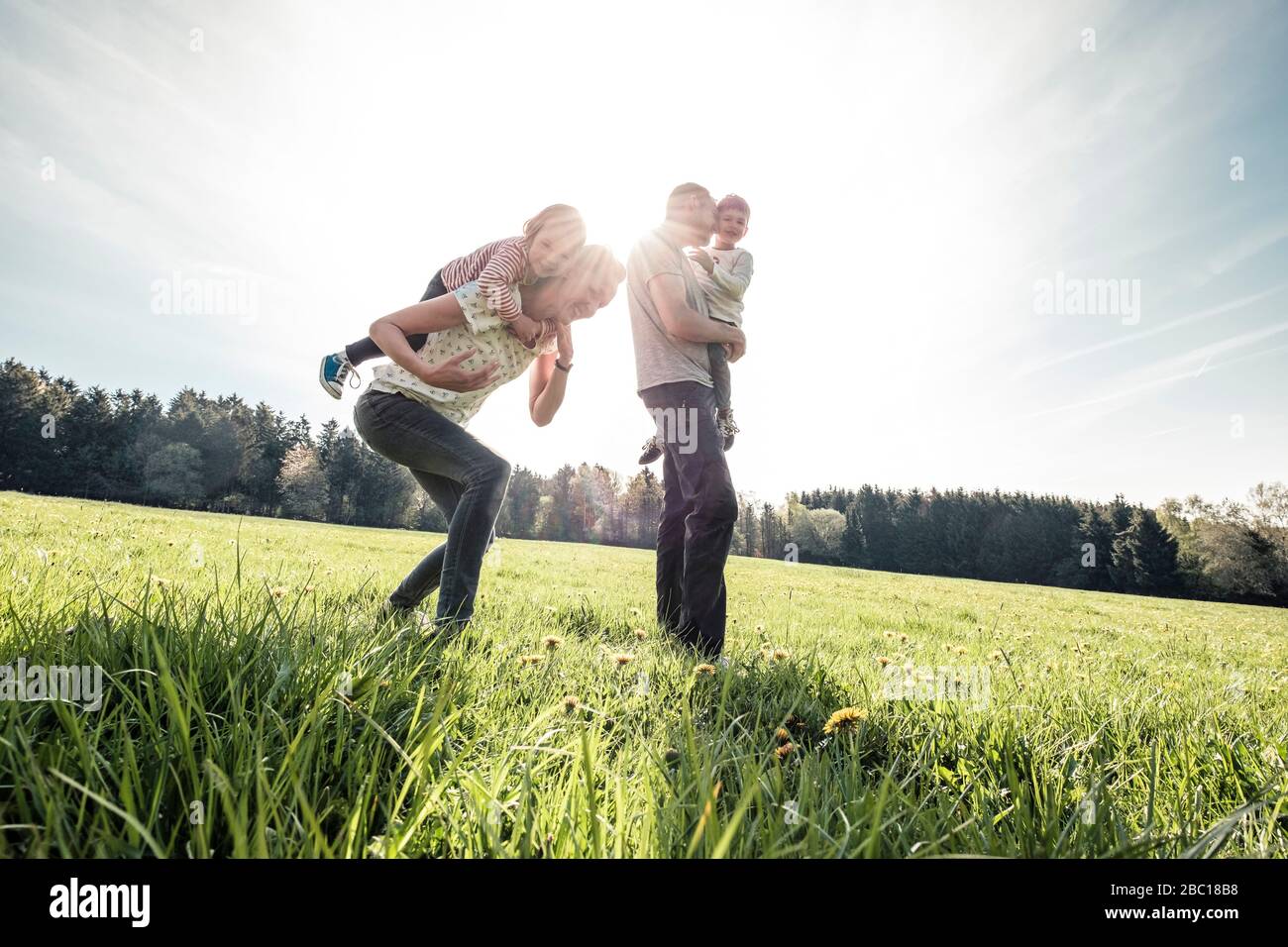 Happy family with two kids on a meadow in spring Stock Photo - Alamy