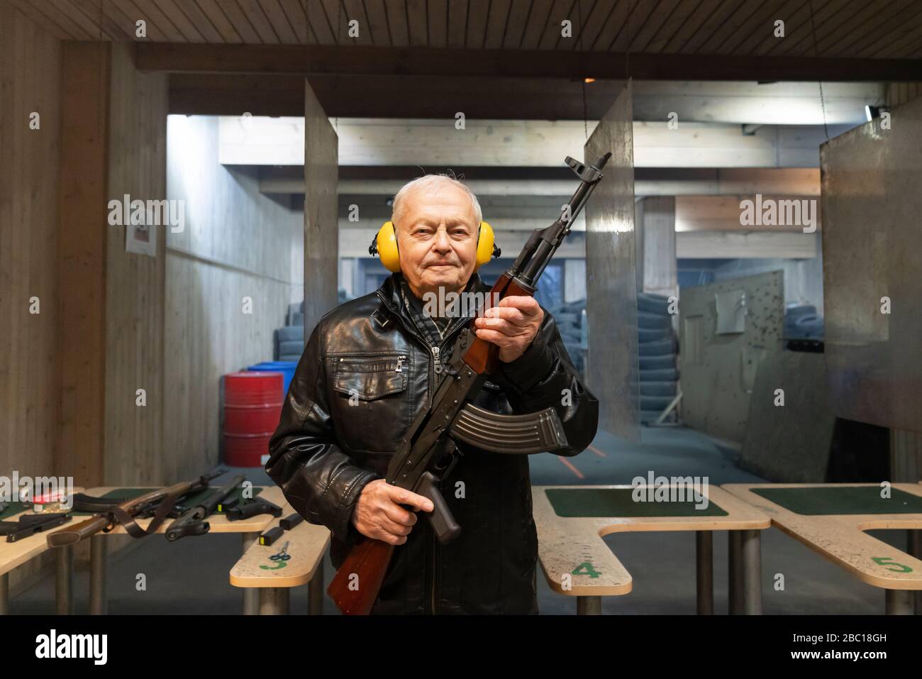 Portrait of senior man with a gun in shooting range Stock Photo - Alamy
