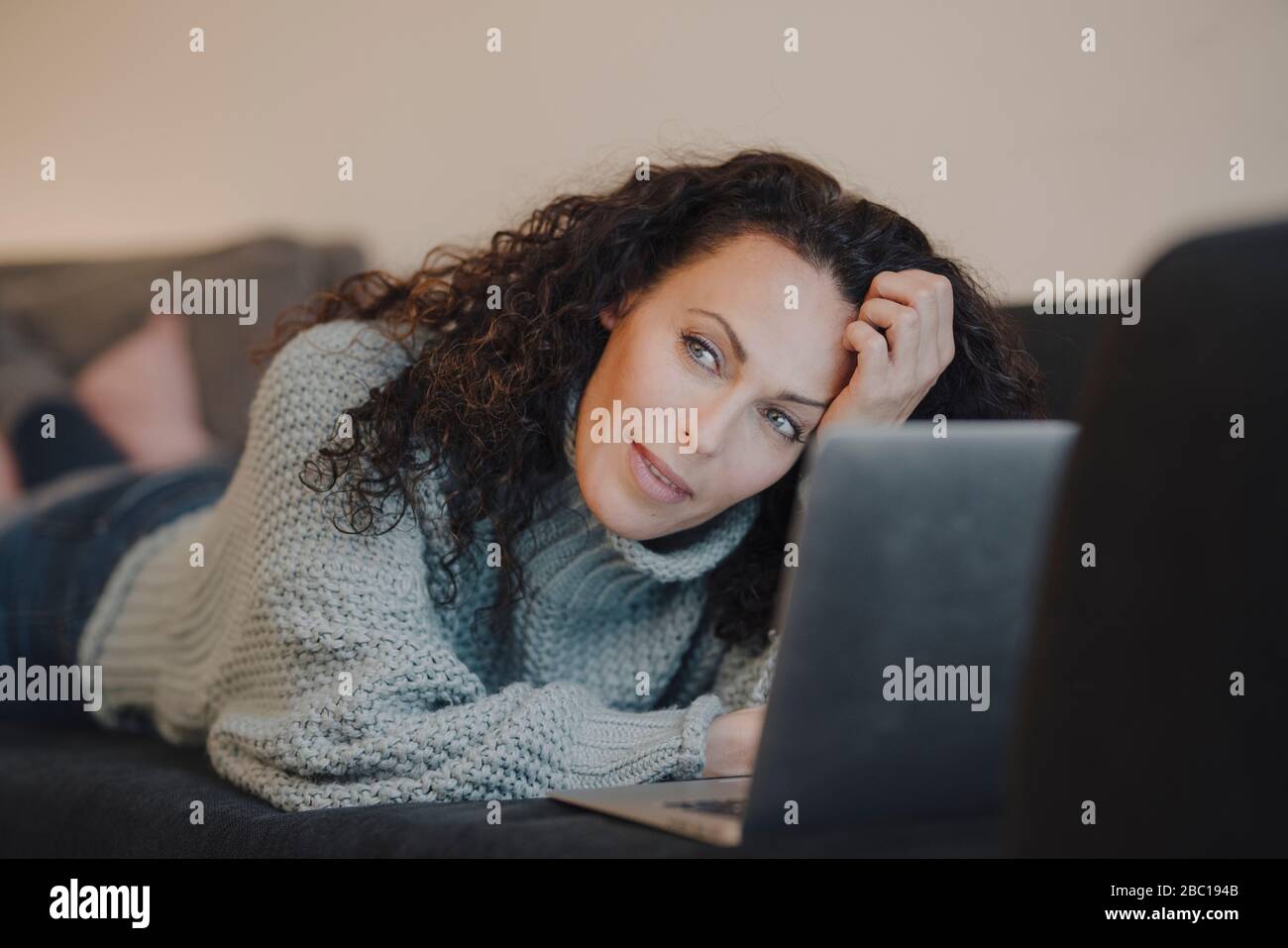 Woman thinking with laptop hi-res stock photography and images - Alamy