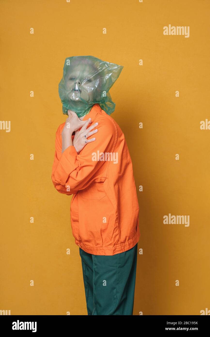 Portrait of young woman wearing orange jacket in front of yellow ...