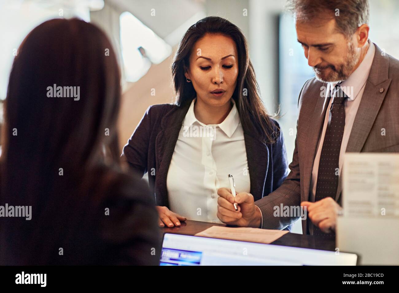 Business people checking in at reception desk in hotel Stock Photo - Alamy