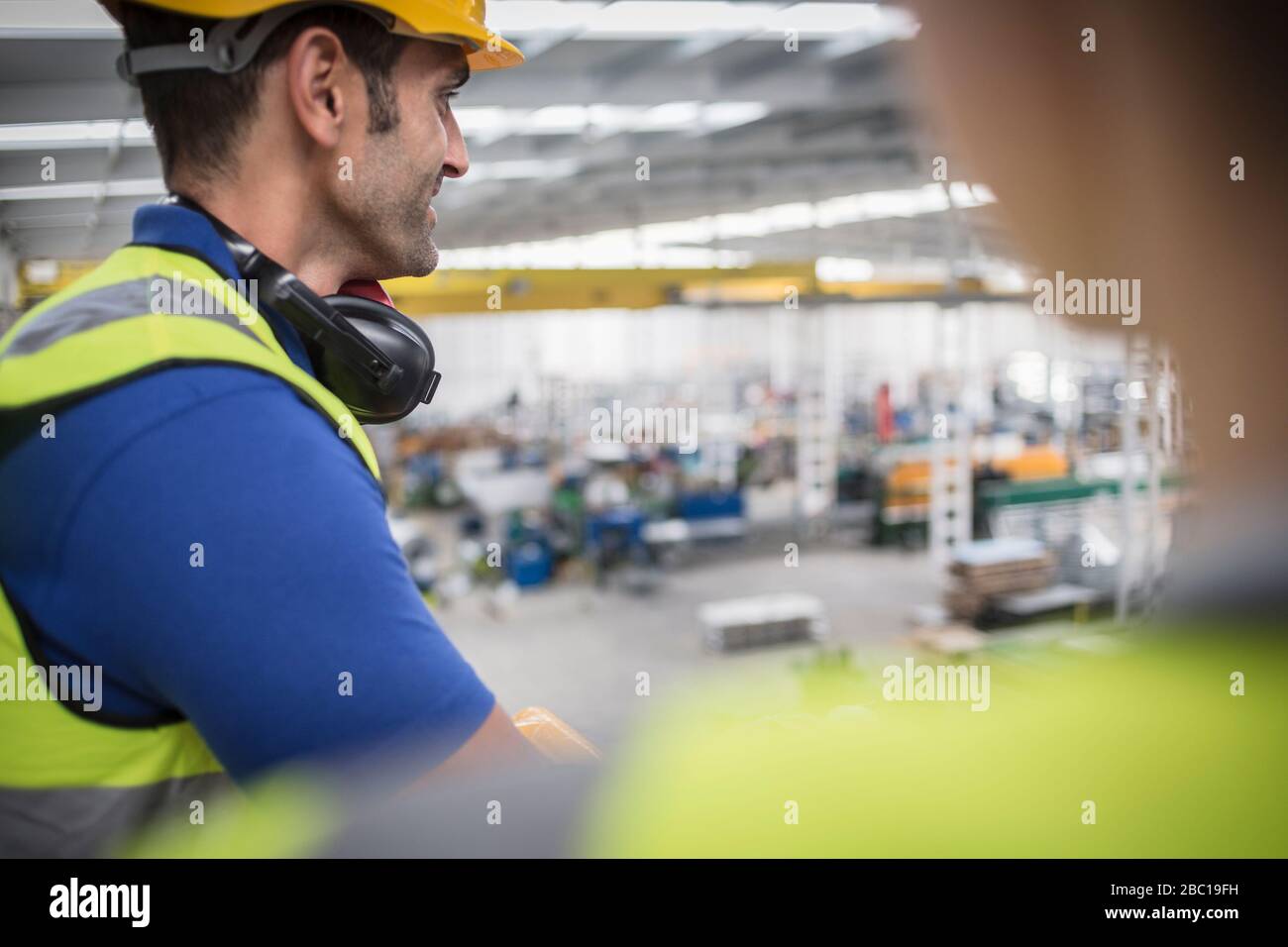 Male worker on platform watching factory Stock Photo - Alamy