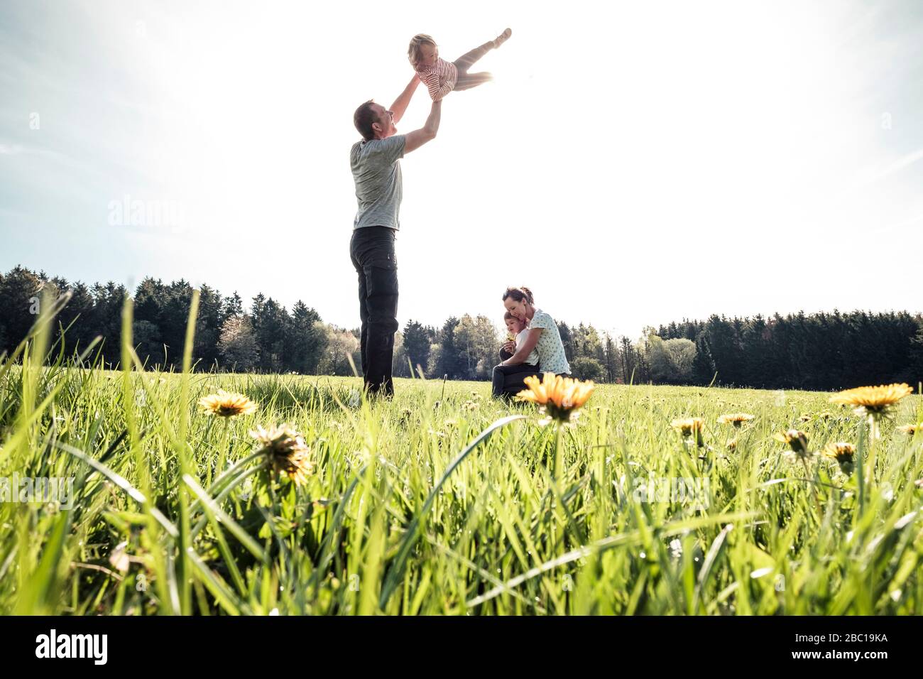 Happy family with two kids on a meadow in spring Stock Photo - Alamy