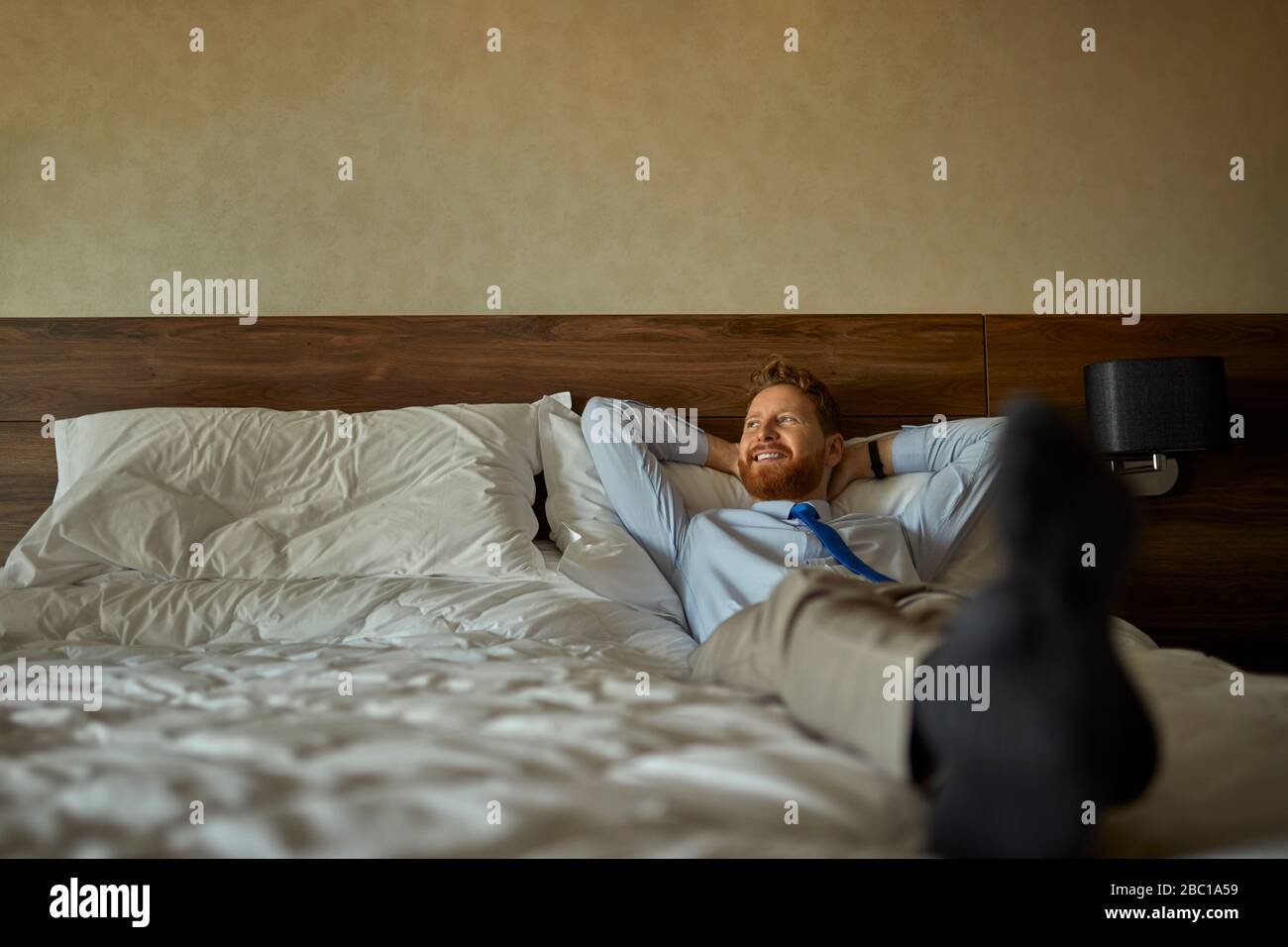 Man lying in bed hands behind head hi-res stock photography and images ...