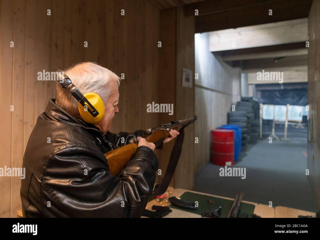 Senior man aiming with a gun in shooting range Stock Photo - Alamy