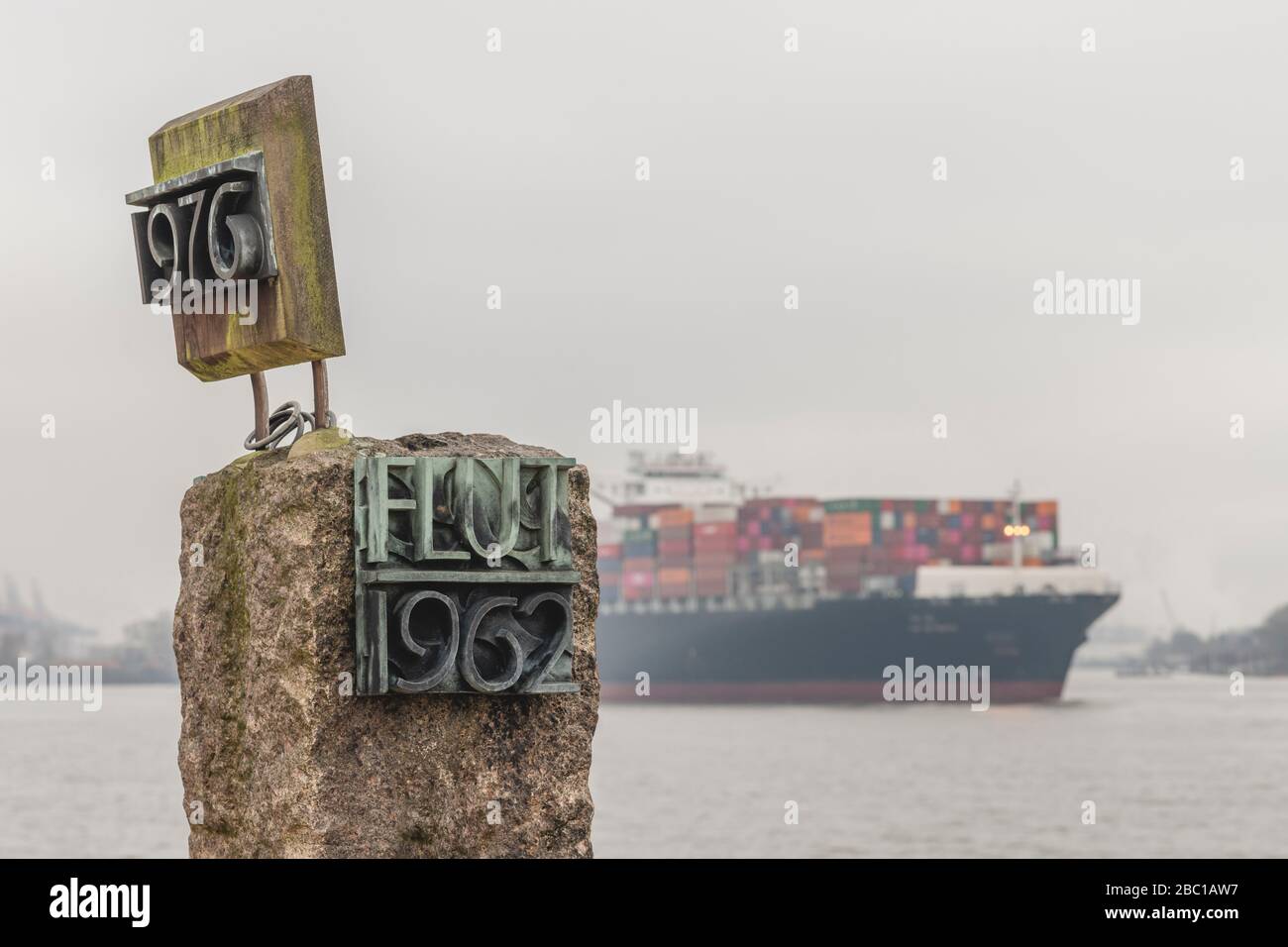 Germany, Hamburg, Coastal flood memorial with container ship in ...