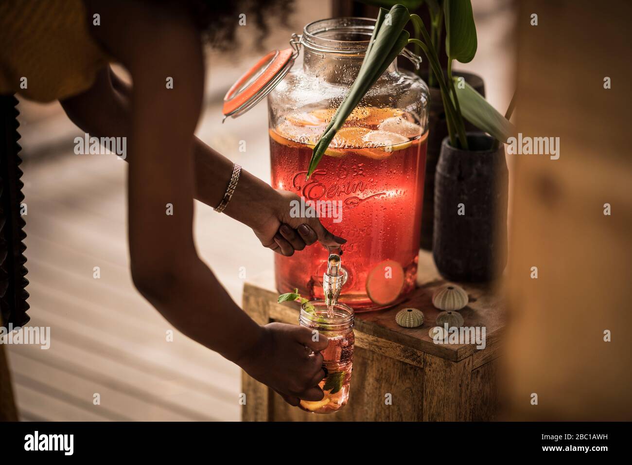 Close-up of woman pouring fresh ice tea drink into glass Stock Photo ...