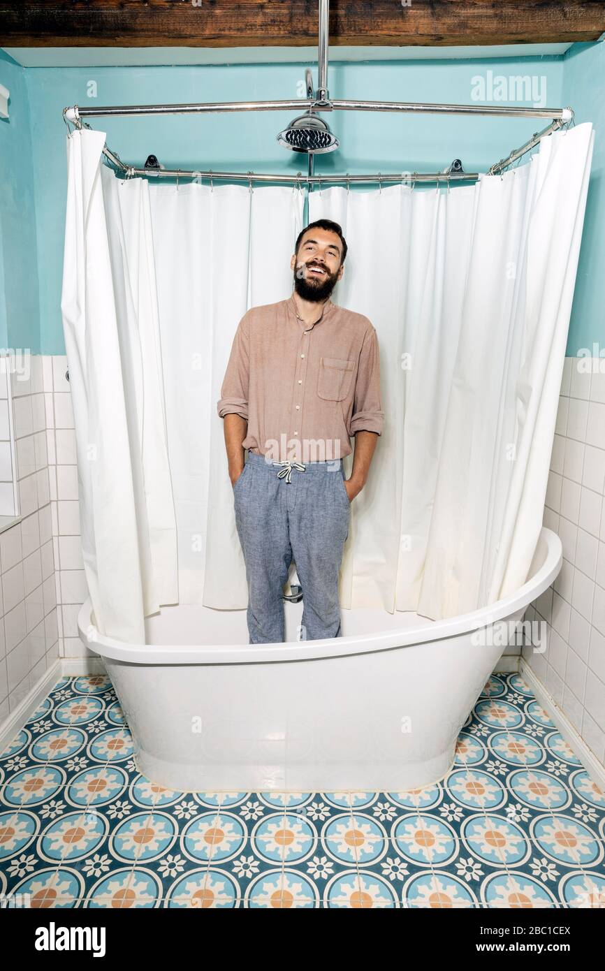 Young man standing in bath tub, laughing Stock Photo - Alamy