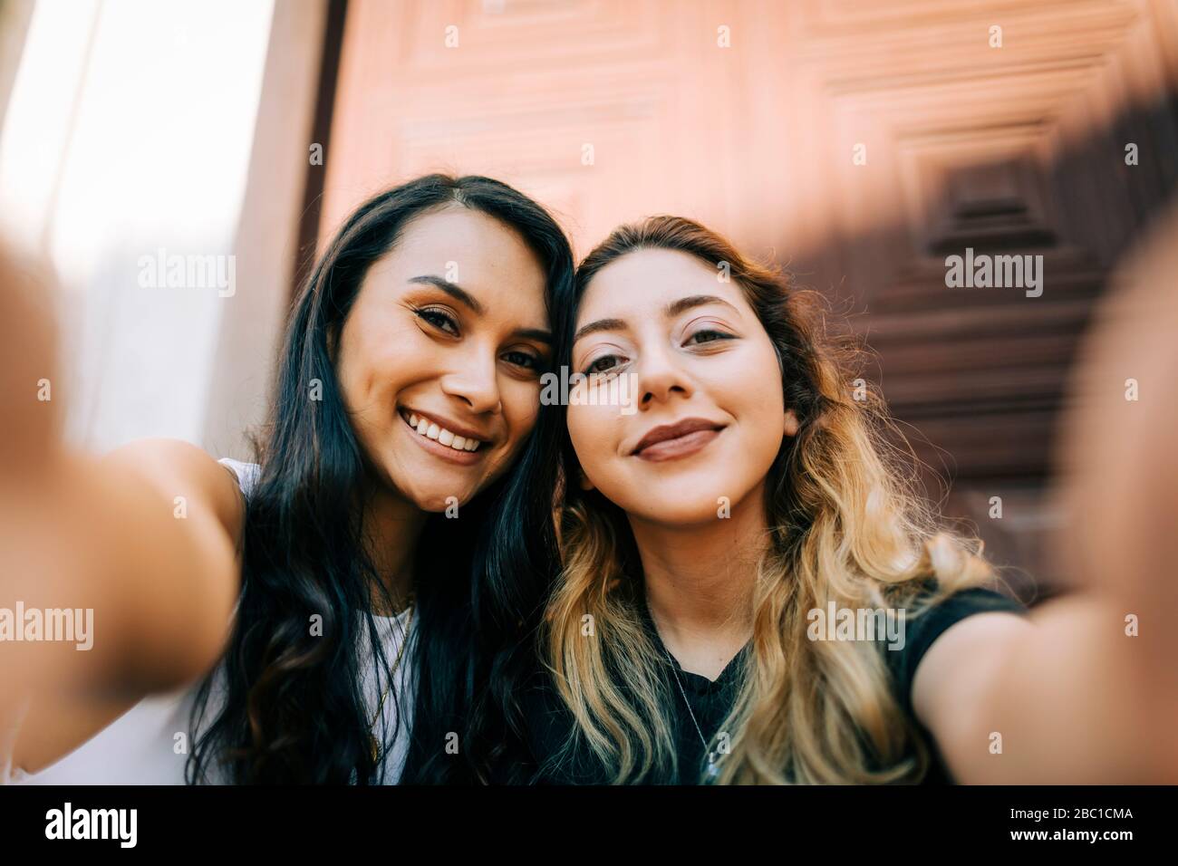 Portrait of two happy friends taking selfie Stock Photo - Alamy