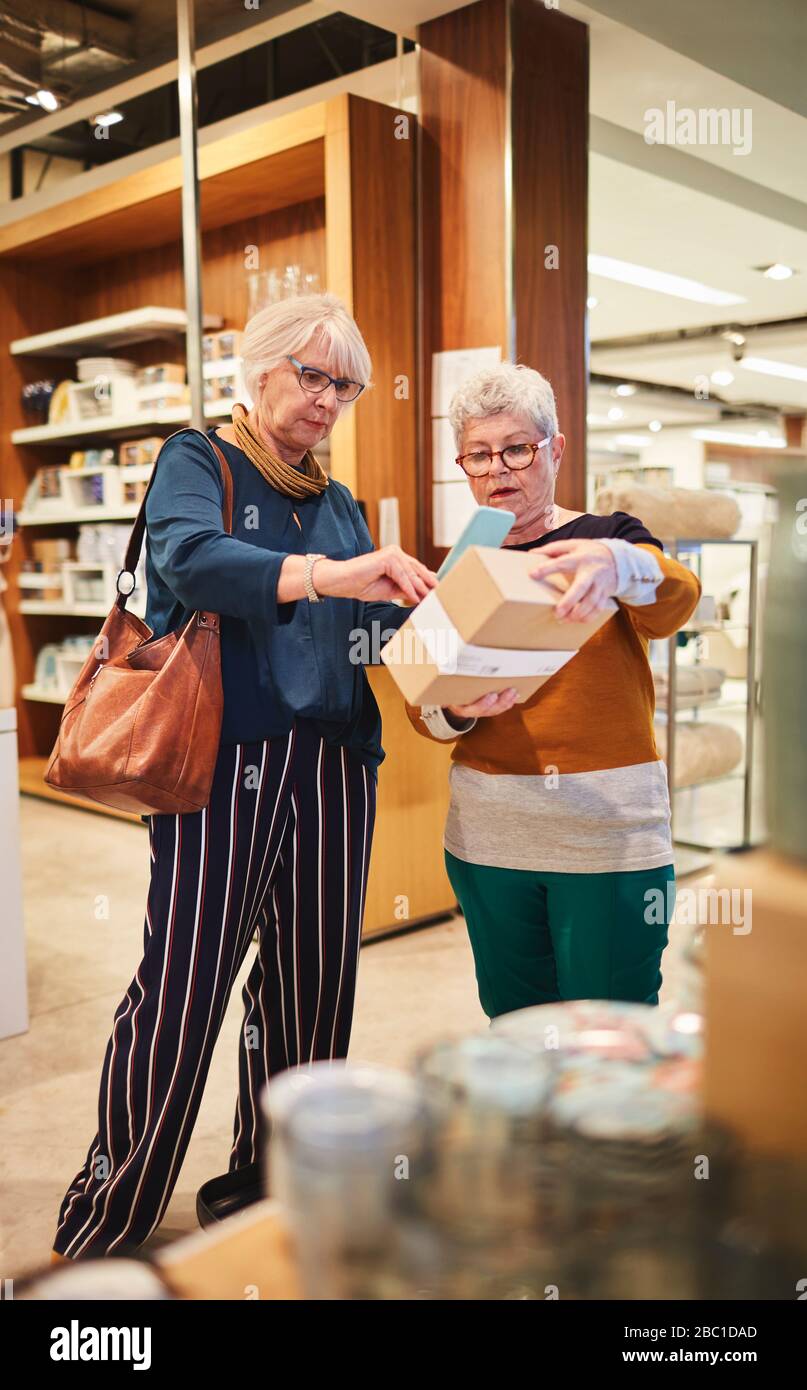 Senior women with smart phone shopping in home good store Stock Photo ...