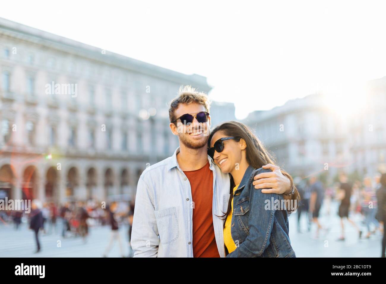 Happy young couple on a square in the city at sunset, Milan, Italy ...