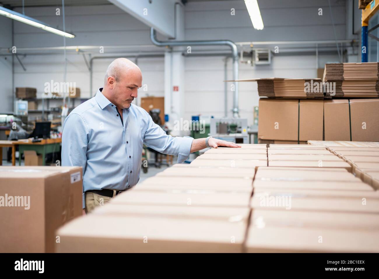 Businessman in a factory storage Stock Photo - Alamy