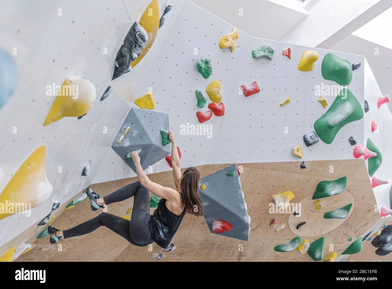 Woman bouldering in climbing gym Stock Photo - Alamy