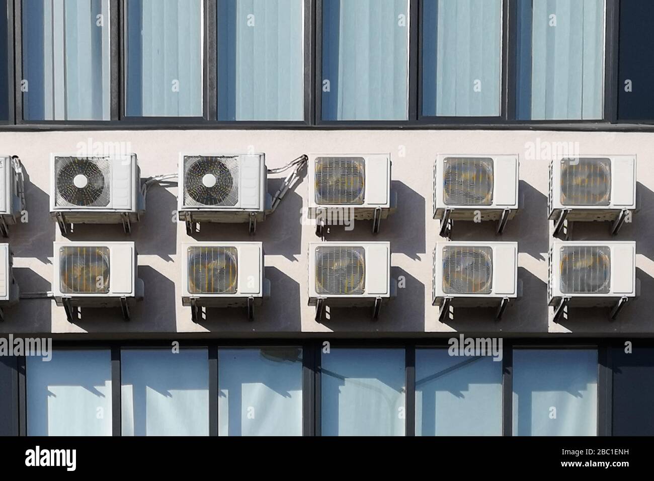 Many air conditioners on the facade of an office building. Temperature ...
