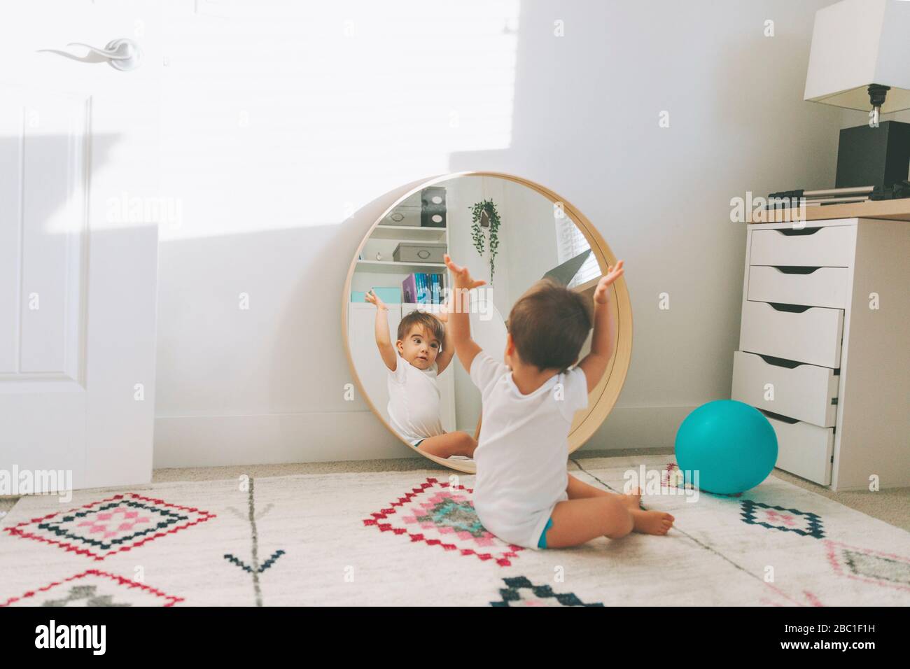 Baby looking at himself in the mirror Stock Photo - Alamy