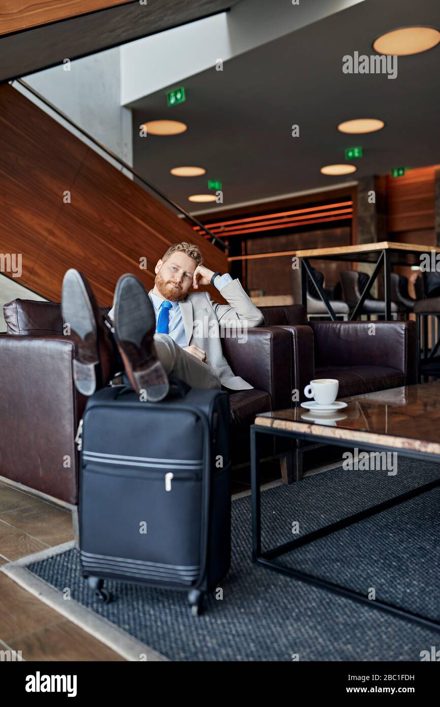 Businessman relaxing in hotel lobby Stock Photo - Alamy