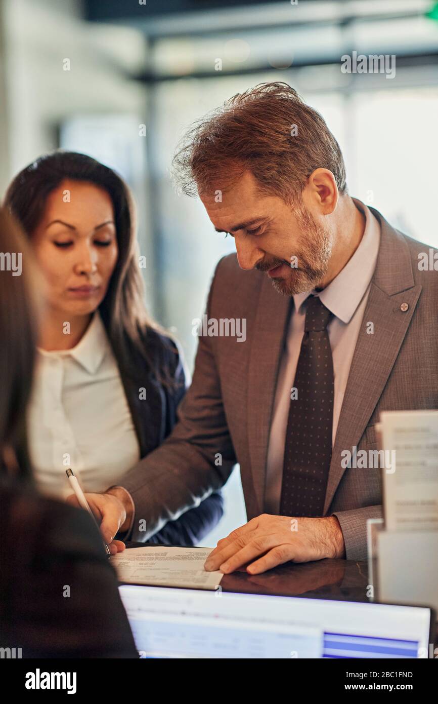 Business people checking in at reception desk in hotel Stock Photo - Alamy