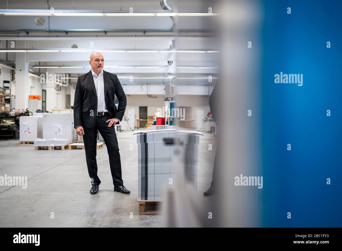 Businessman standing in front of a printing machine hi-res stock ...