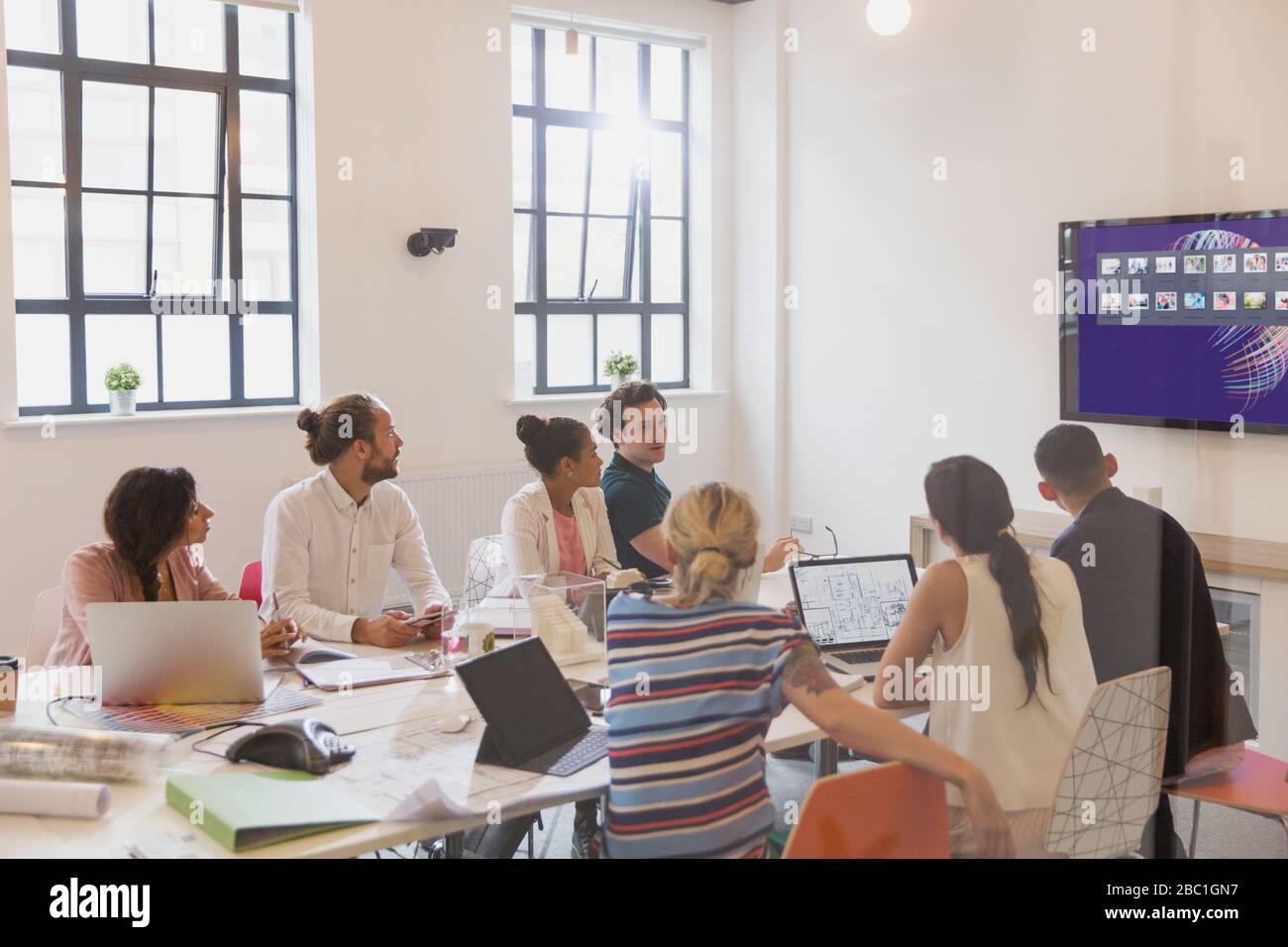 Architects using television screen in conference room meeting Stock ...