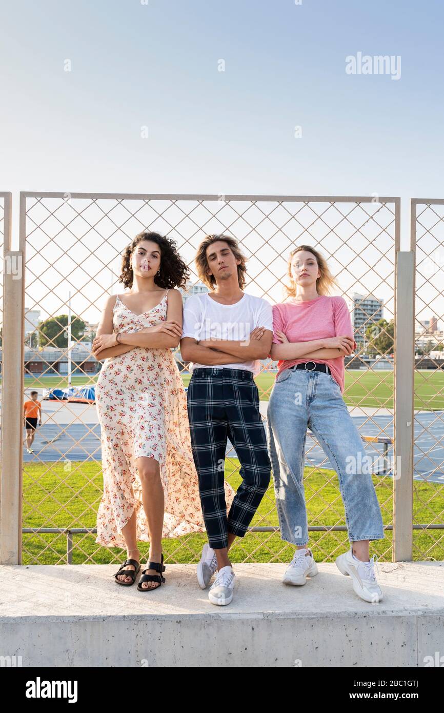 Portrait of cool friends at a wire mesh fence Stock Photo - Alamy
