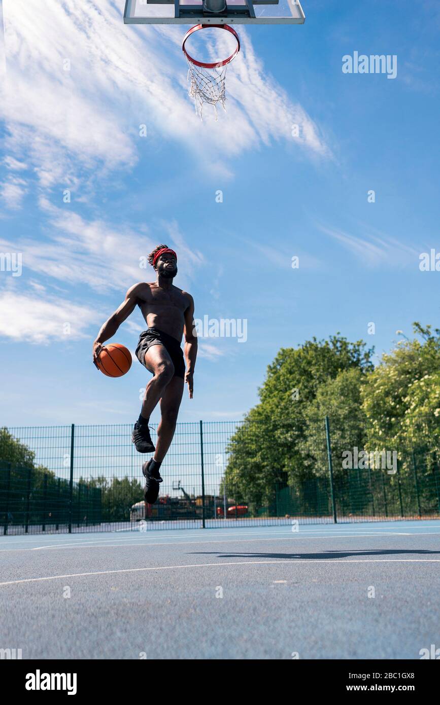 Man playing basketball, dunking Stock Photo - Alamy