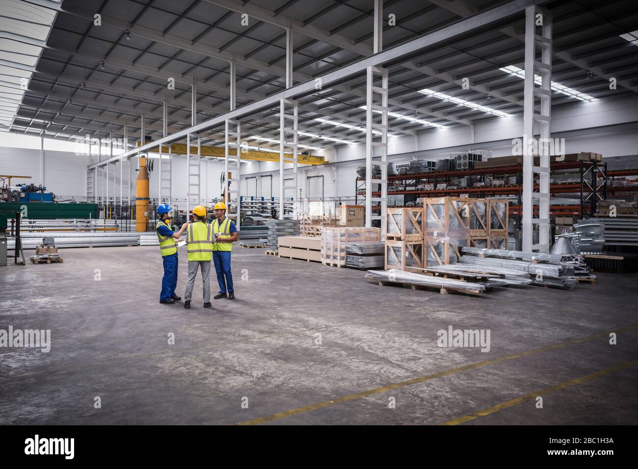 Supervisor and workers talking in warehouse Stock Photo - Alamy