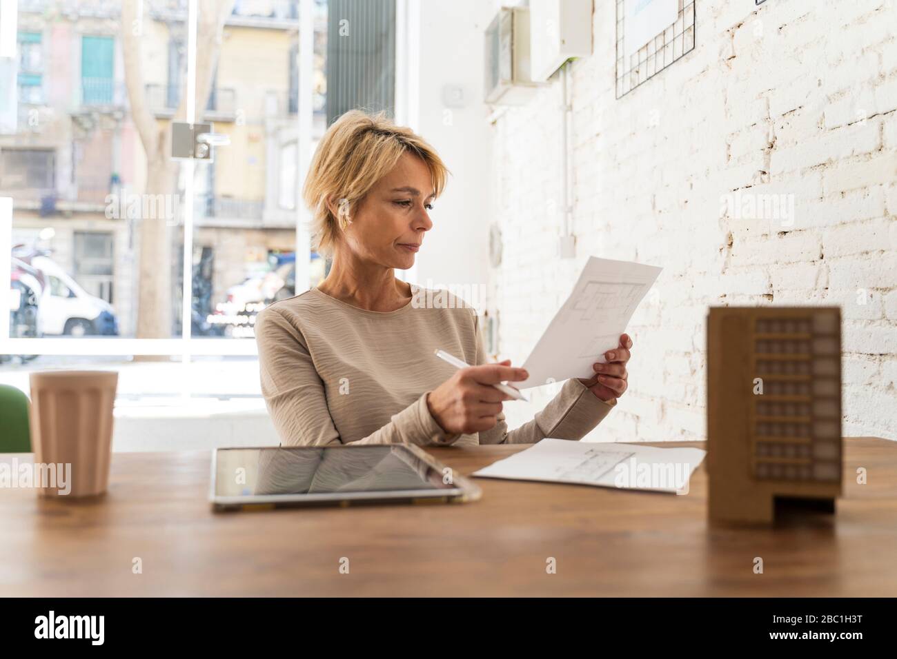 Mature woman working at desk in architectural office Stock Photo - Alamy