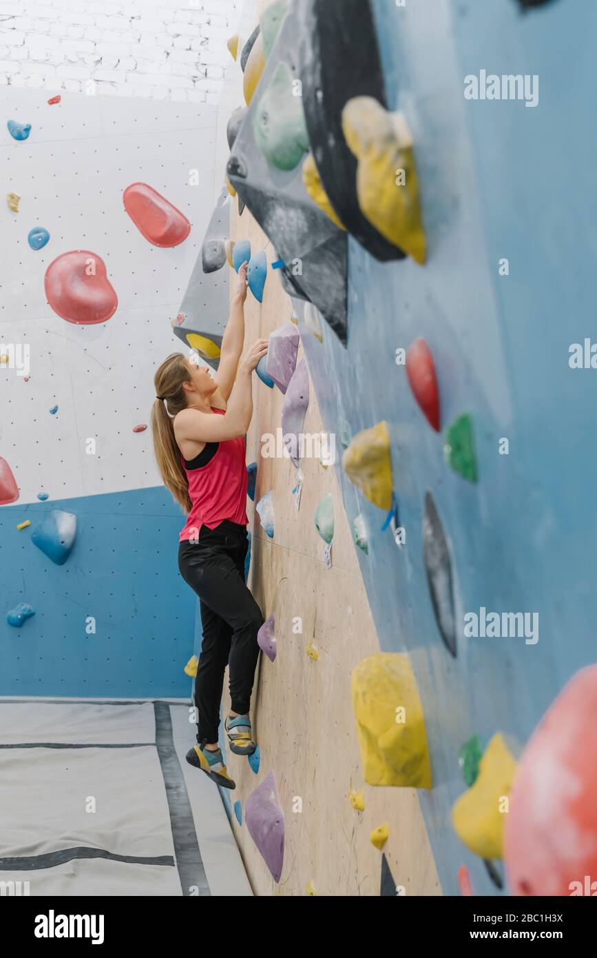 Woman bouldering in climbing gym Stock Photo - Alamy