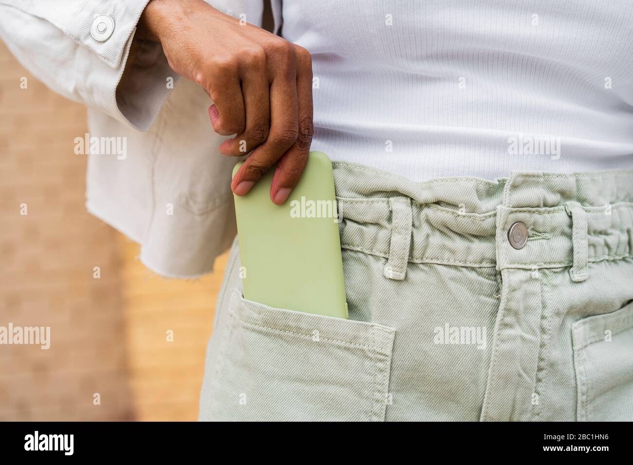 Close-up of woman putting smartphone into her pocket Stock Photo - Alamy