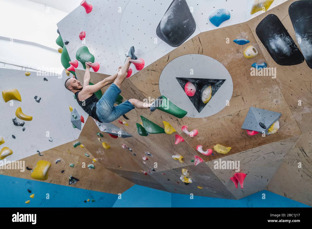 Man bouldering in climbing gym Stock Photo - Alamy