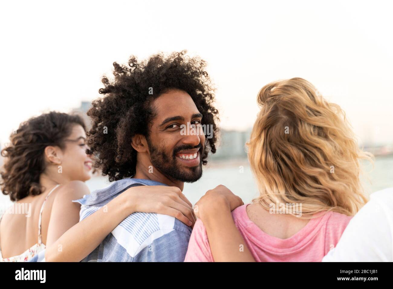 Portrait of happy friends embracing outdoors Stock Photo - Alamy