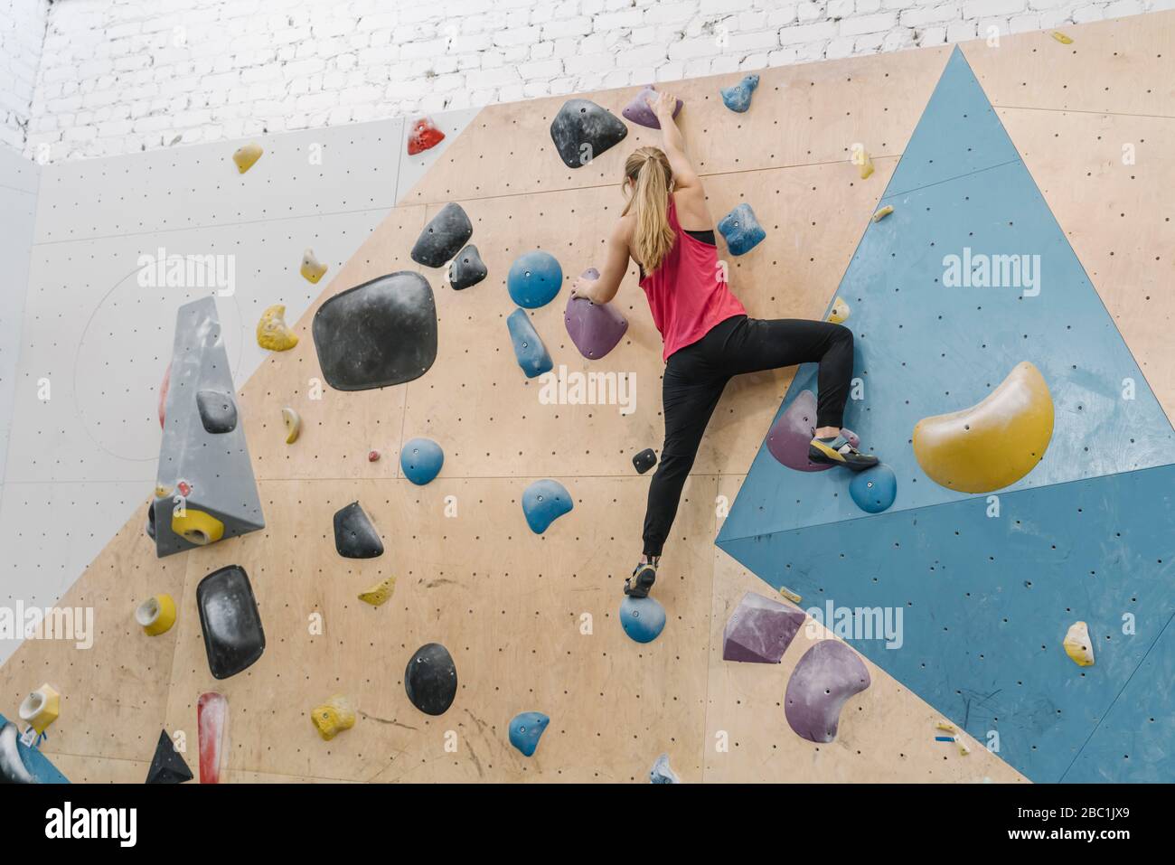 Woman bouldering in climbing gym Stock Photo - Alamy