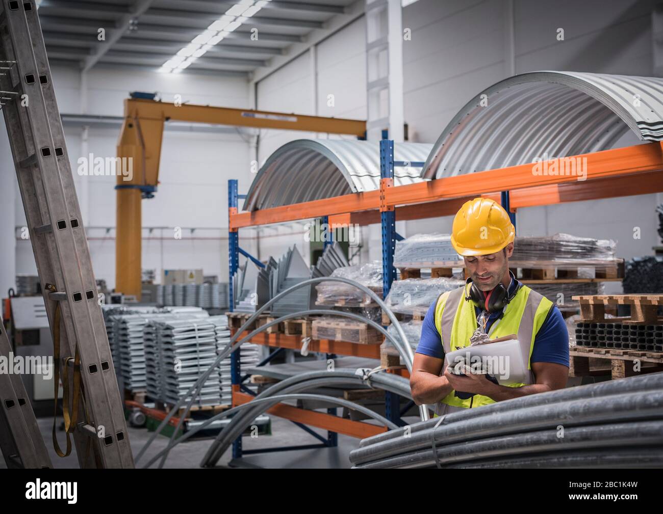 Male supervisor with clipboard in steel factory Stock Photo - Alamy
