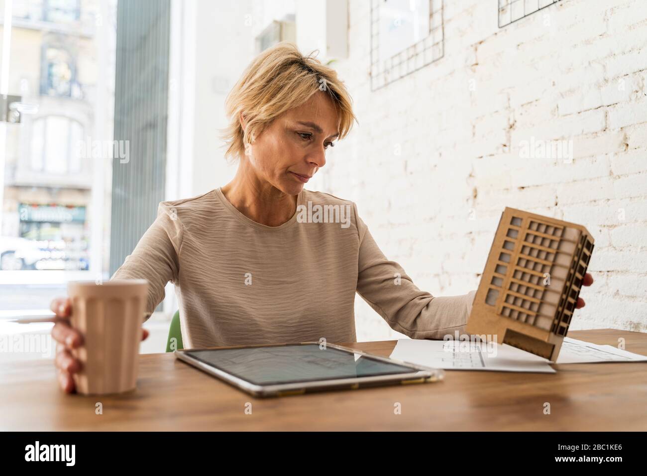 Mature woman working at desk in architectural office Stock Photo - Alamy