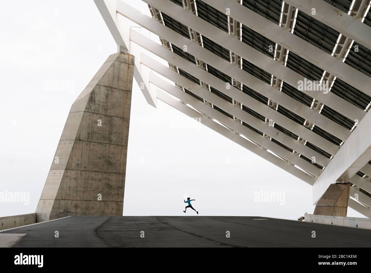 Young woman jogging at a modern building Stock Photo - Alamy