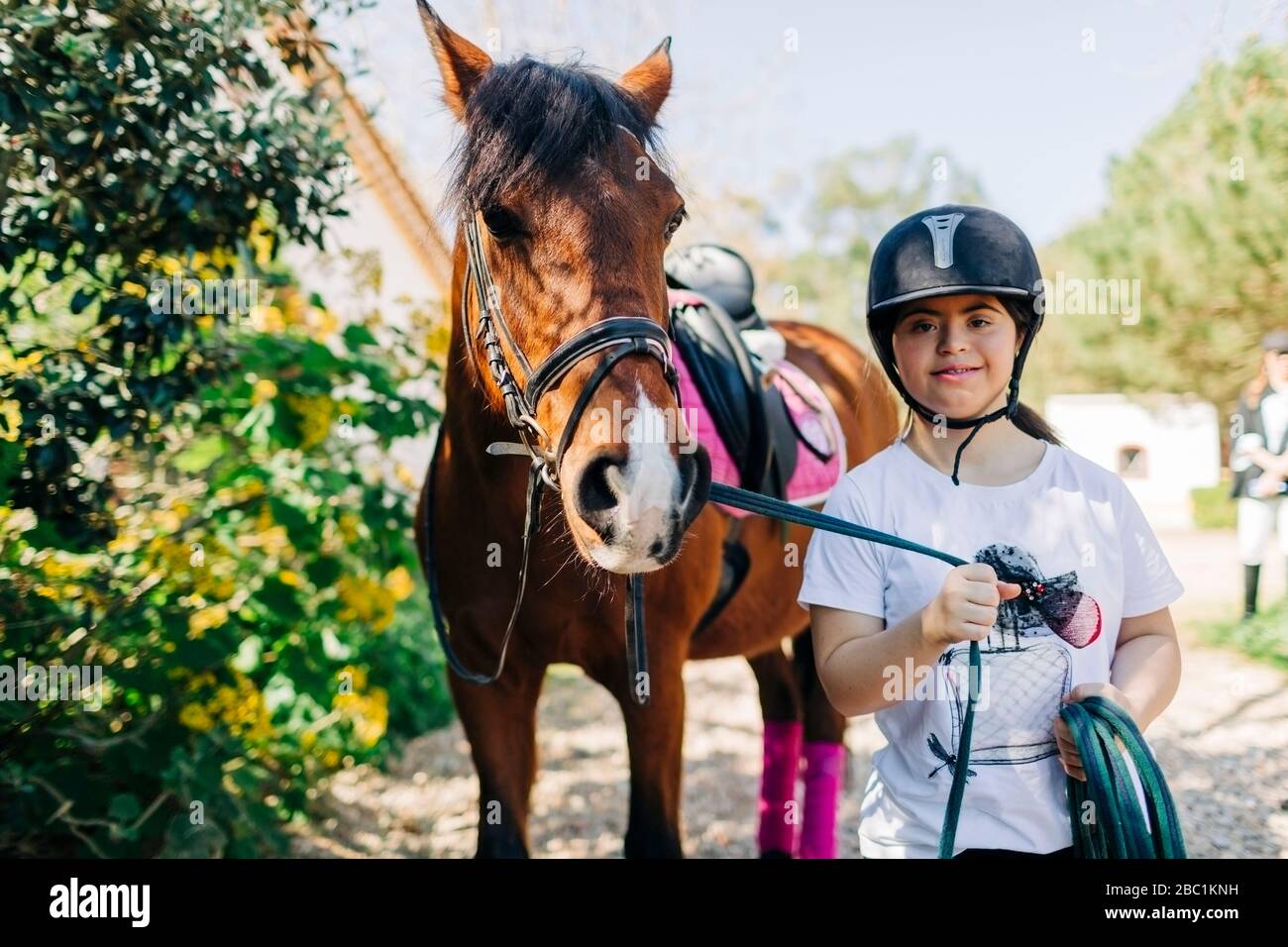 Teenager with down syndrome taking care of horse and preparing horse to ...