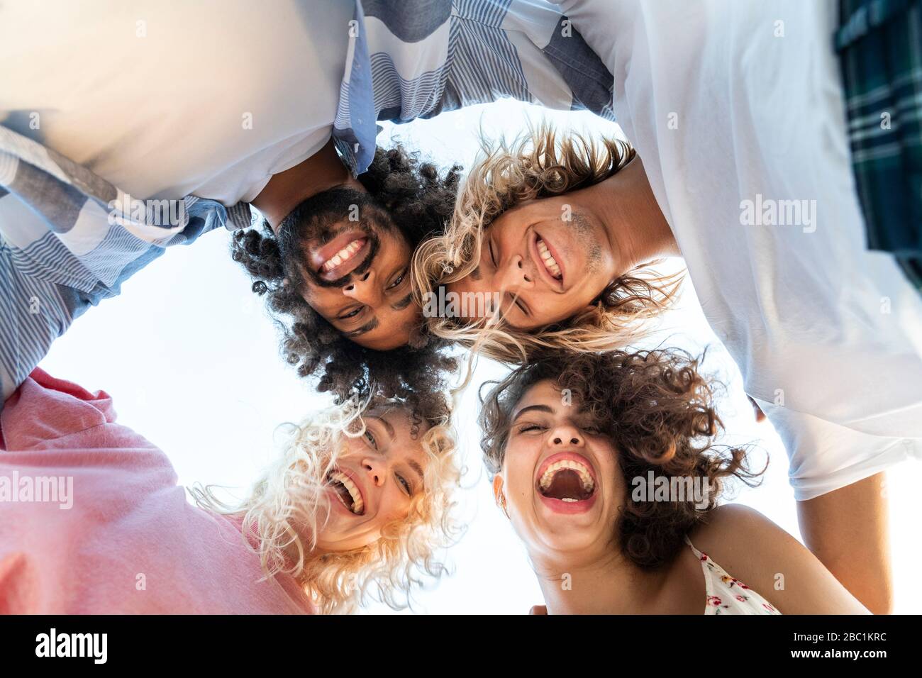 Portrait of happy friends huddling outdoors Stock Photo - Alamy