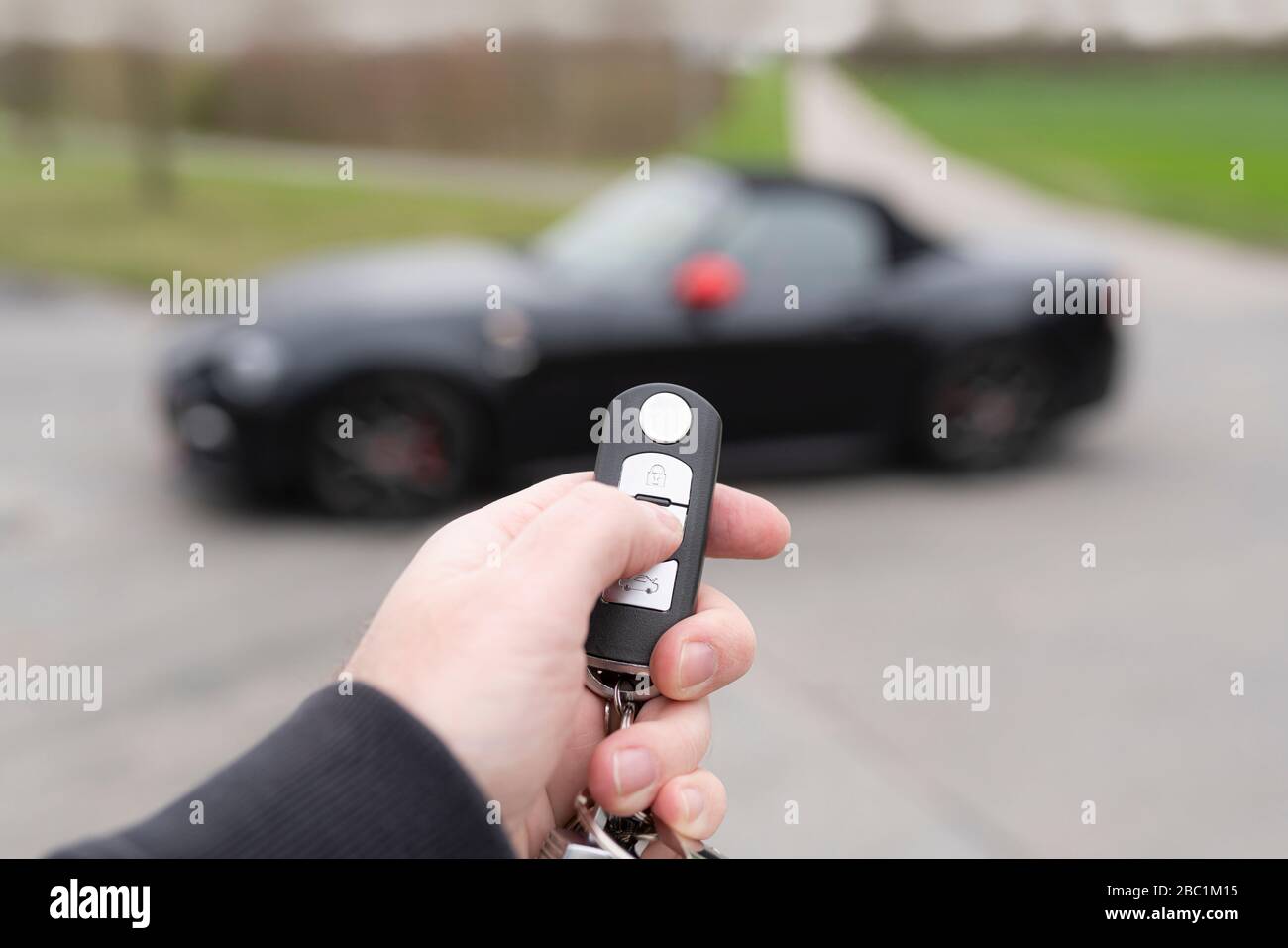 Hand with key opening sports car Stock Photo - Alamy