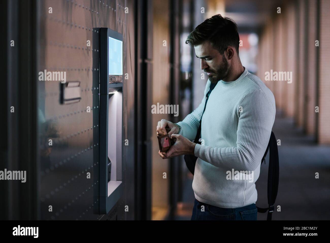 Man withdrawing money at an ATM in the city Stock Photo - Alamy